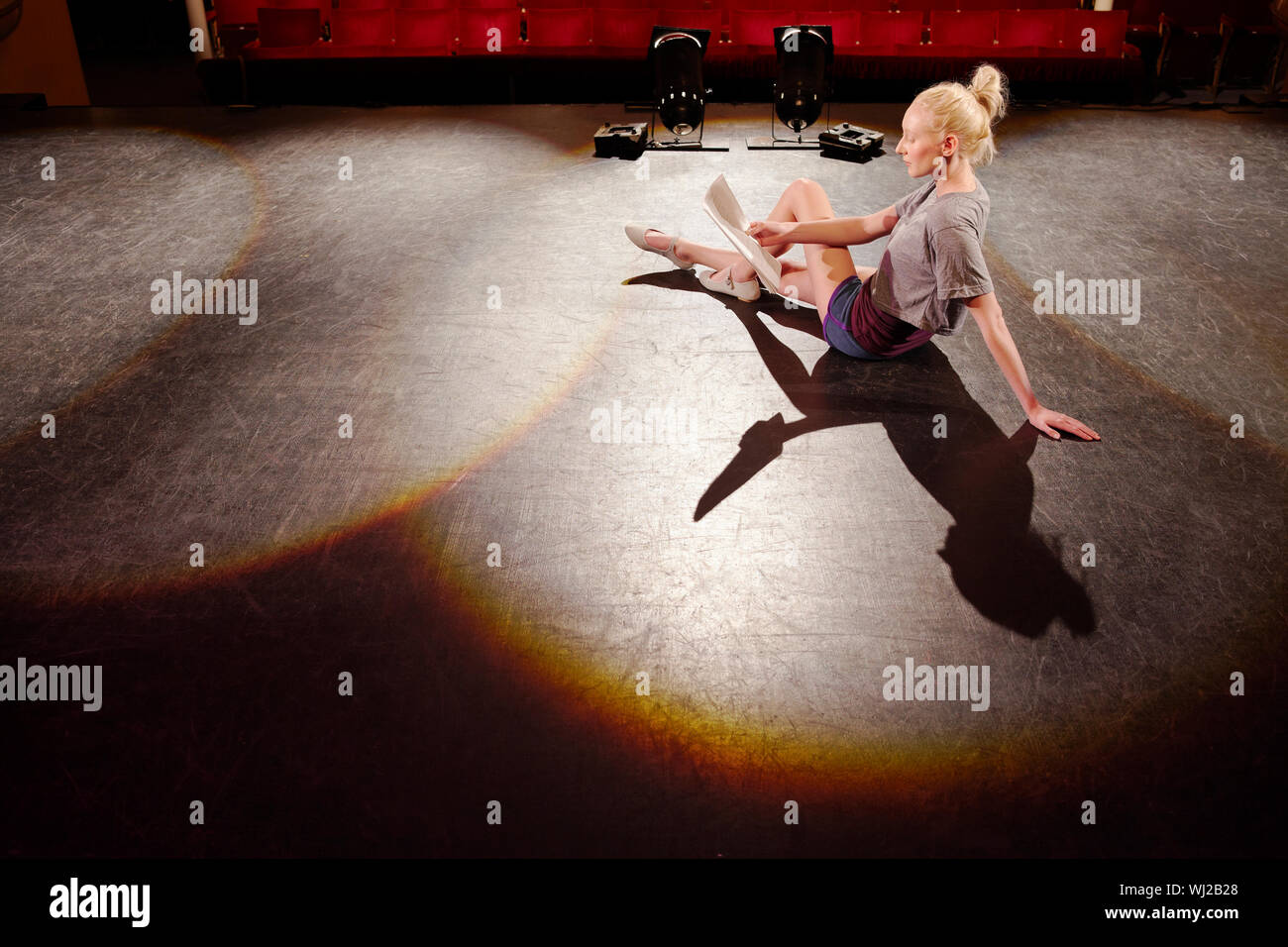 Full length side view of a young woman reading script on stage Stock ...