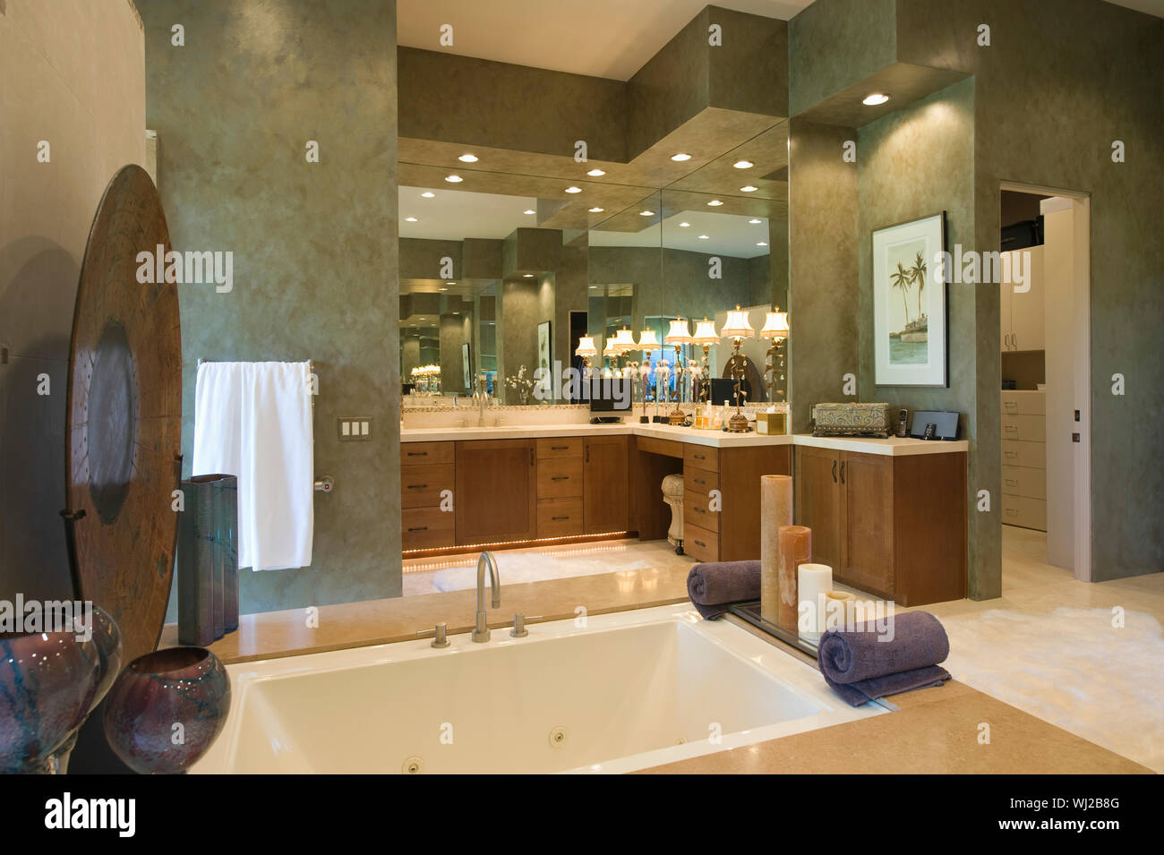 Closeup of sunken bath with cabinets and mirror in background at ...