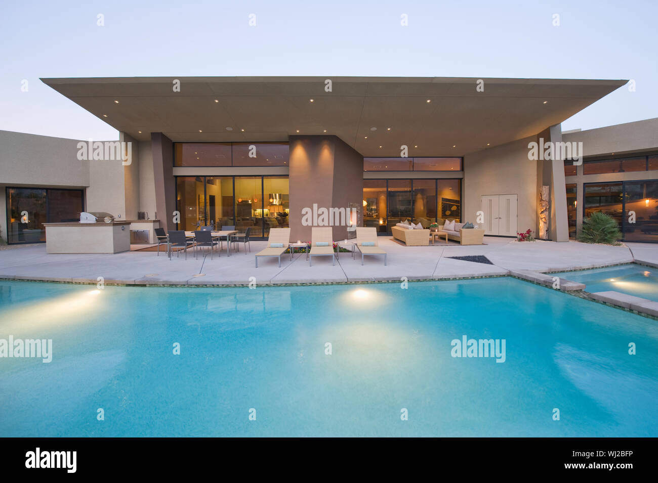 Swimming pool and paved seating area in front of modern home Stock ...