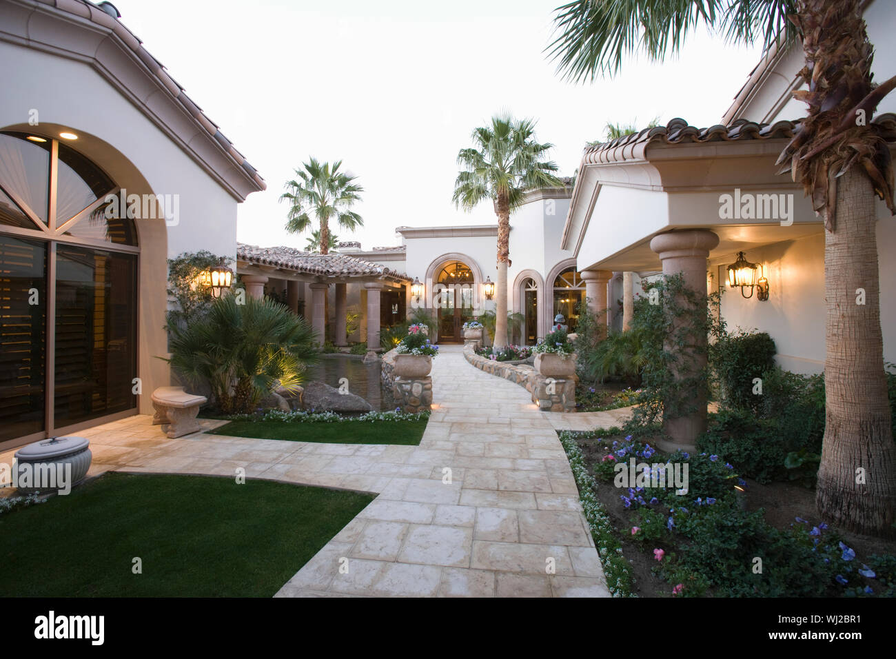 View of garden pathway leading to residential structures Stock Photo ...