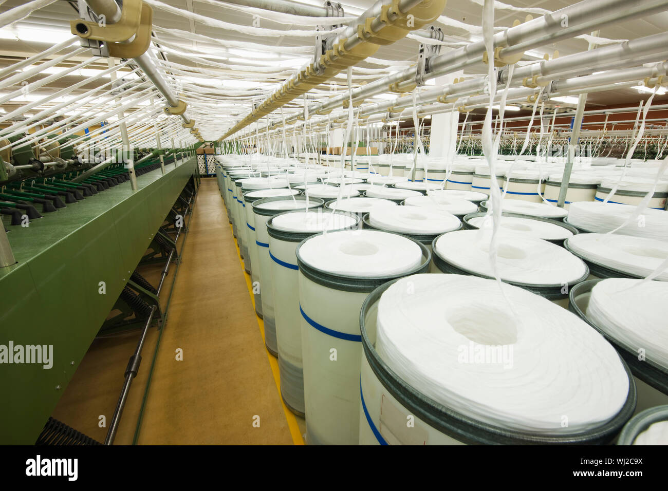 Rolls of fabric and machinery in spinning factory Stock Photo - Alamy