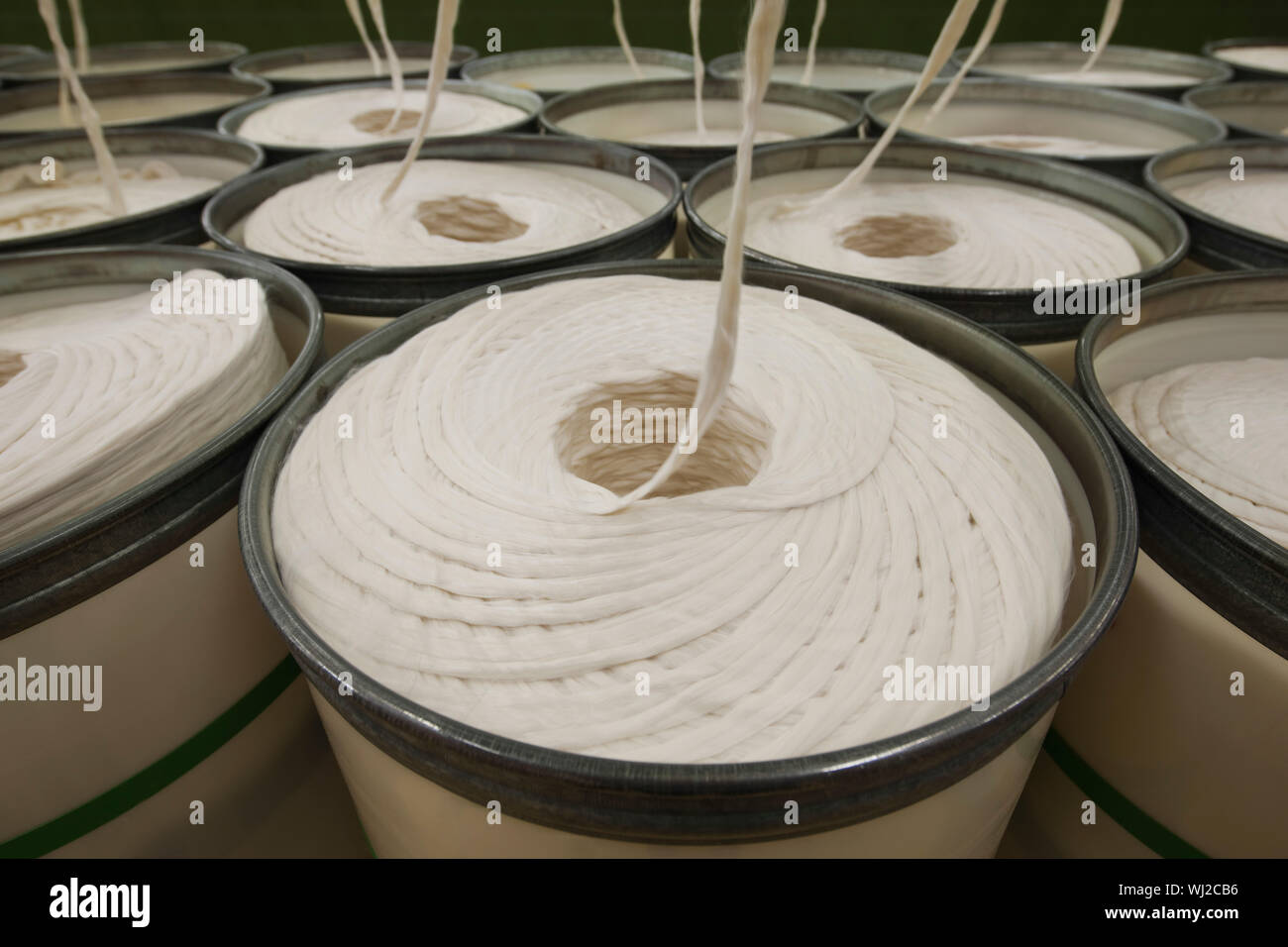 Rolls of fabric and machinery in spinning factory Stock Photo - Alamy