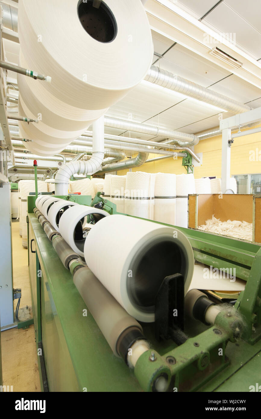 Rolls of fabric and machinery in spinning factory Stock Photo - Alamy