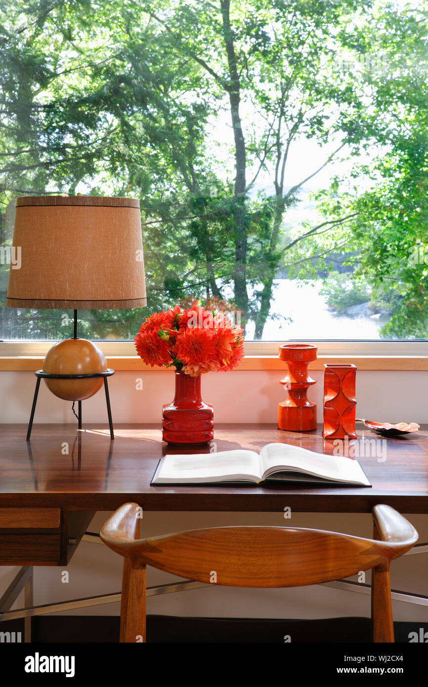 Open book; lamp and retro ornaments on wooden desk by window Stock ...