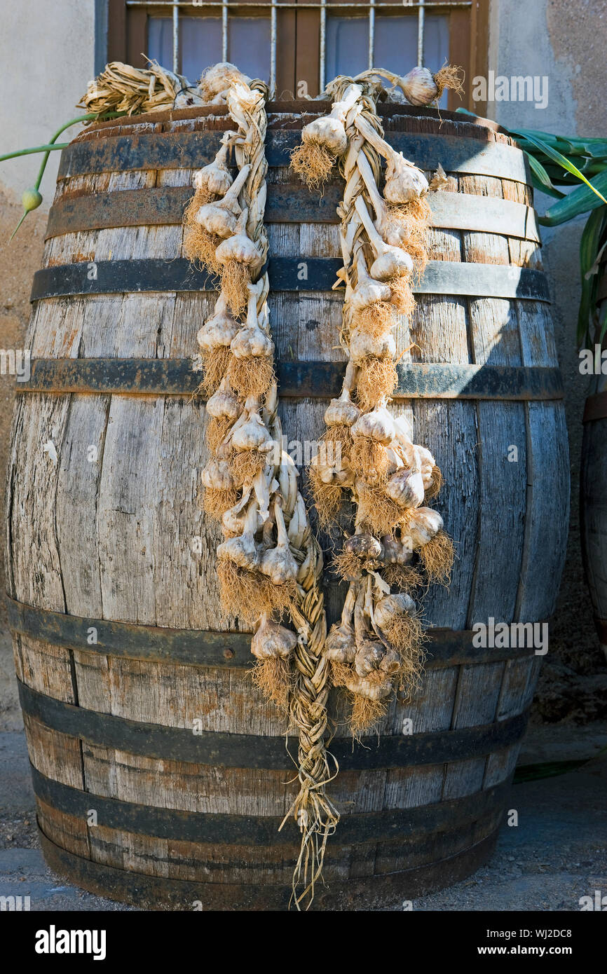 String of garlic hanging from wooden cask Stock Photo - Alamy