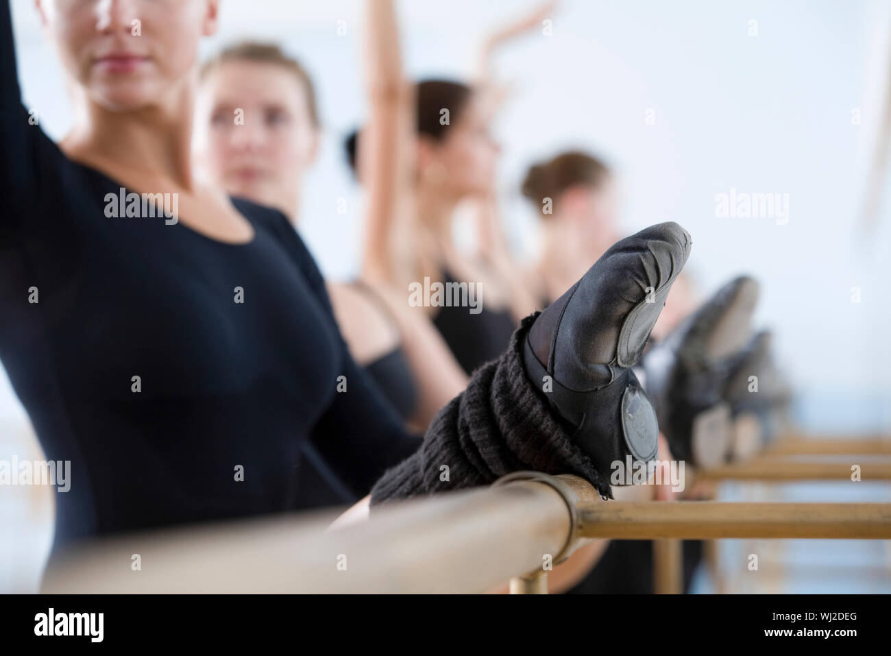 Row of ballet dancers practicing at the barre in rehearsal room Stock ...