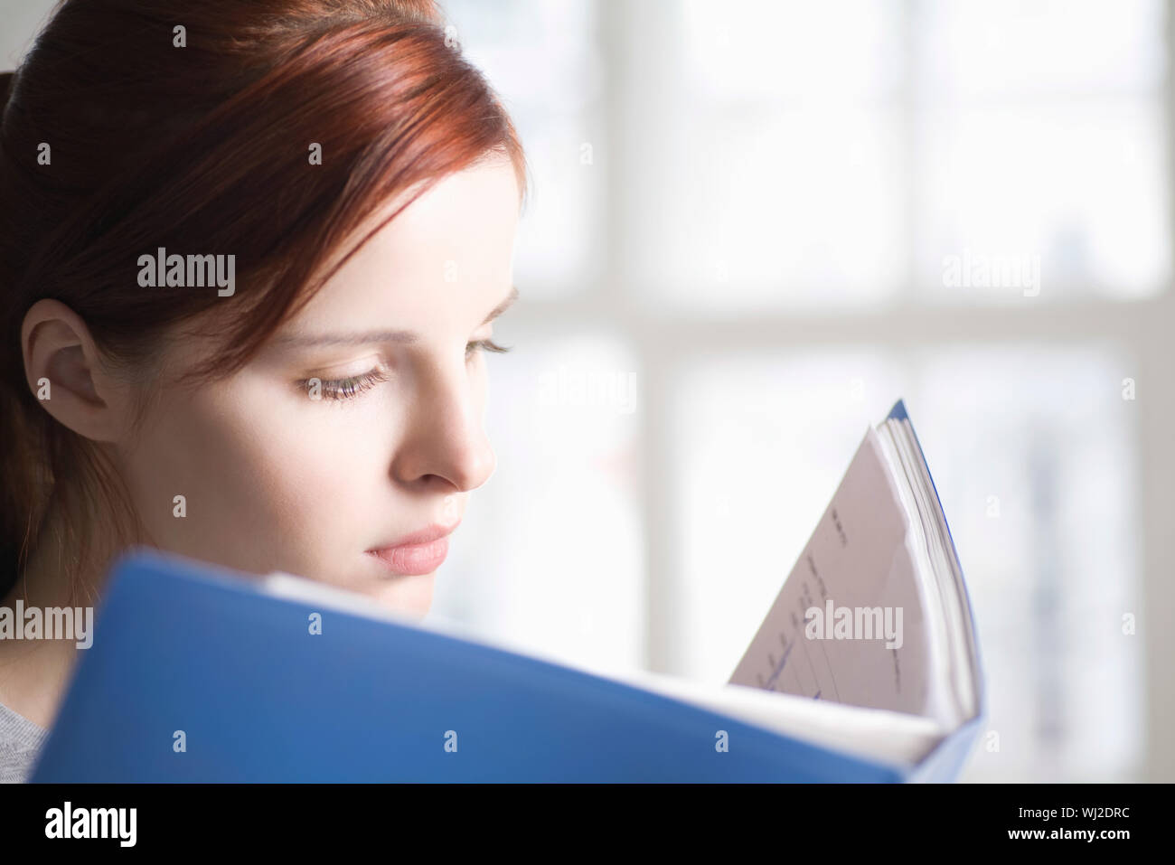 Beautiful young woman reviewing documents at home Stock Photo - Alamy