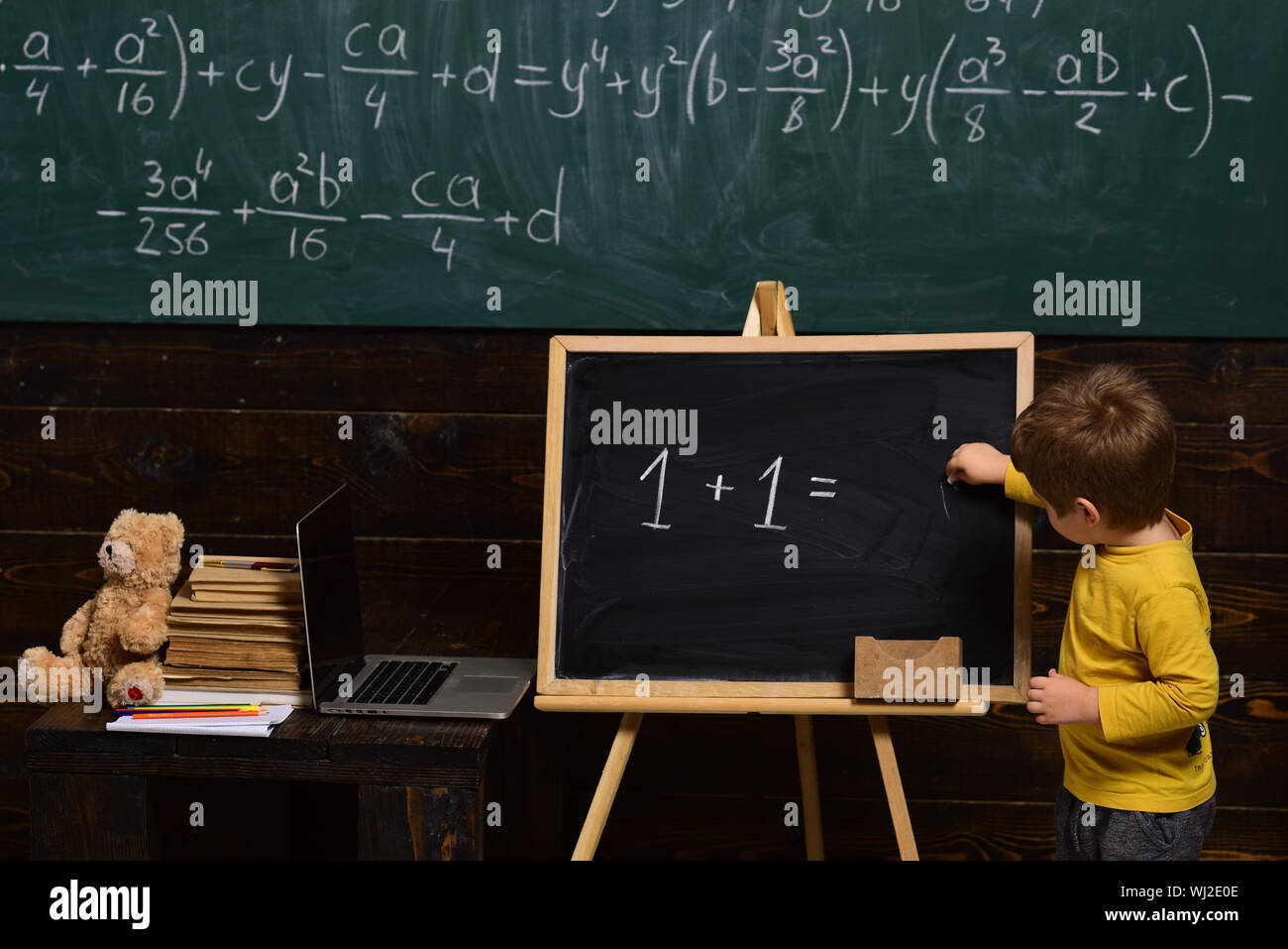 Education concept. Little boy solving equation on chalkboard. Preschool ...