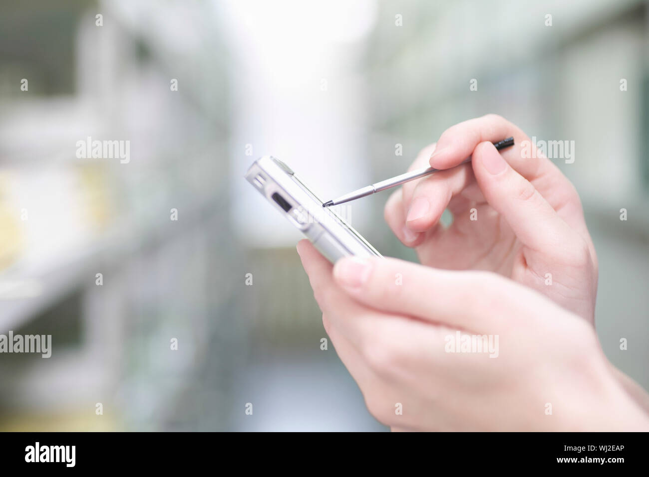 Closeup of woman's hands using PDA in library Stock Photo - Alamy
