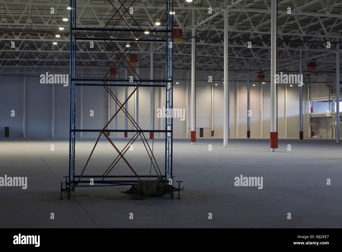Large empty storehouse with scaffold Stock Photo - Alamy