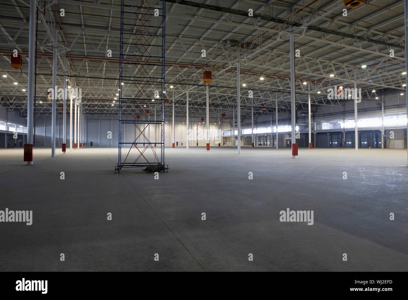 Large empty warehouse with scaffold Stock Photo - Alamy