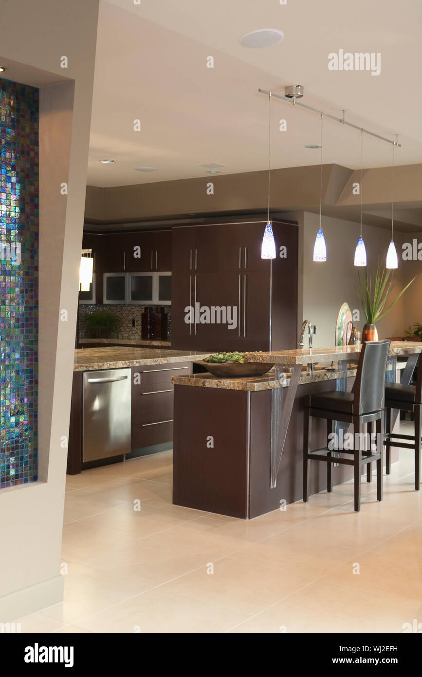Dark brown kitchen with bar stools Stock Photo - Alamy