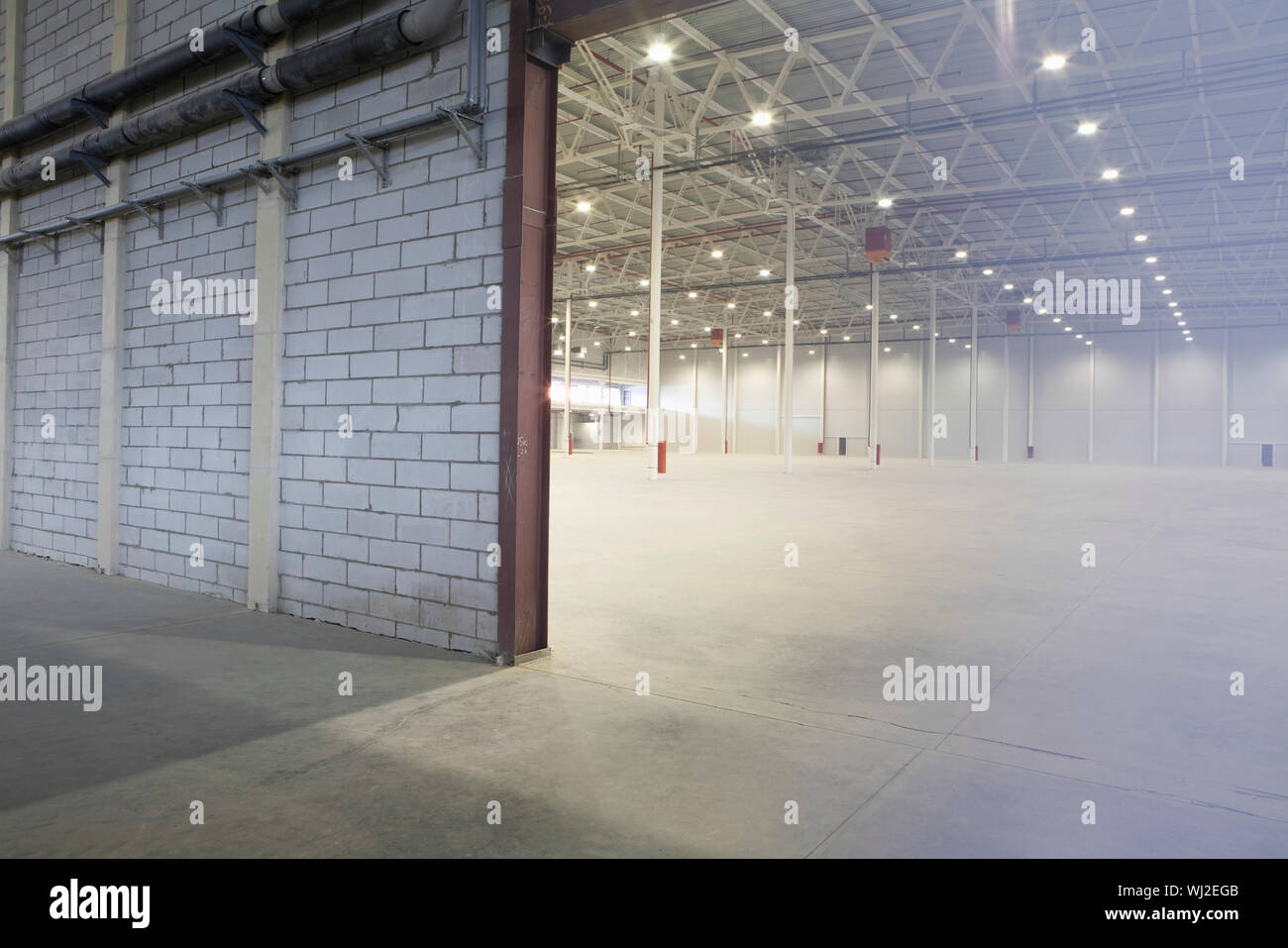 Access door to brightly lit and empty warehouse Stock Photo - Alamy