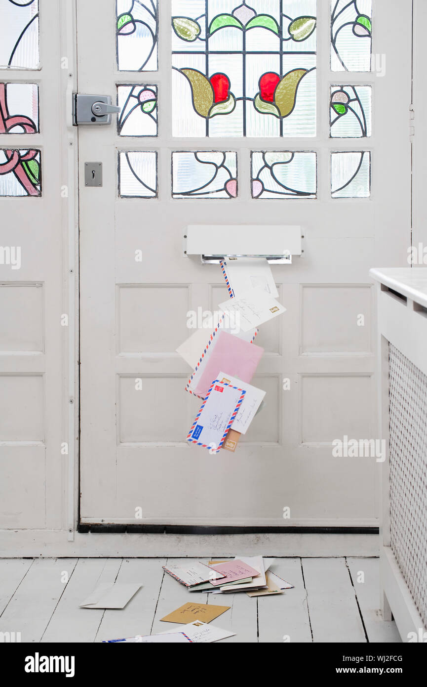 Stream of letters coming through the letter box Stock Photo - Alamy