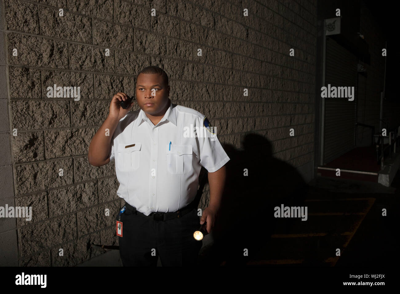 Young male security guard with walkie talkie and torch on duty Stock ...