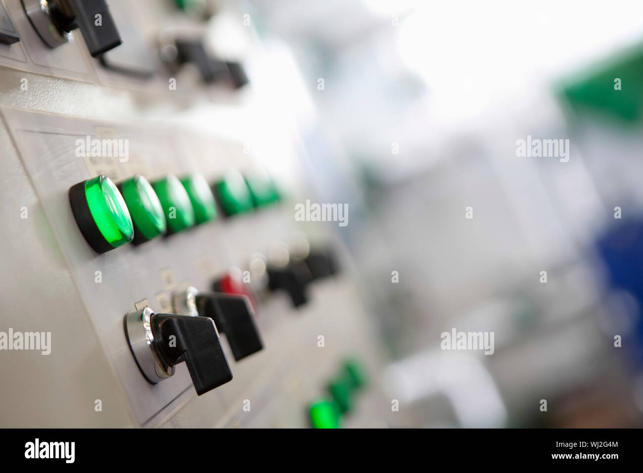 Closeup of lit lights and control dials on manufacturing machinery ...