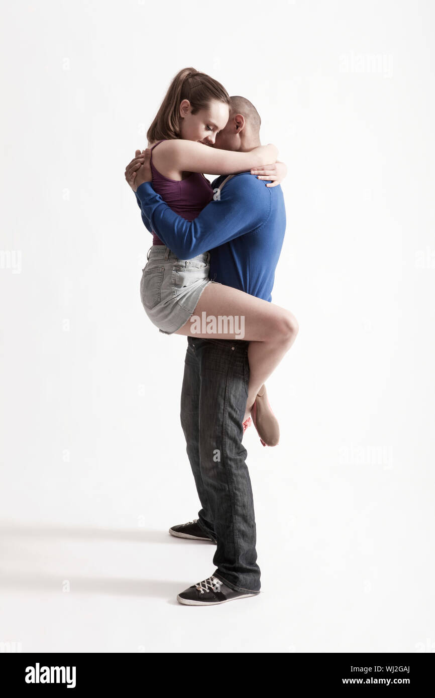 Full length side view of modern dancers embracing over white background ...
