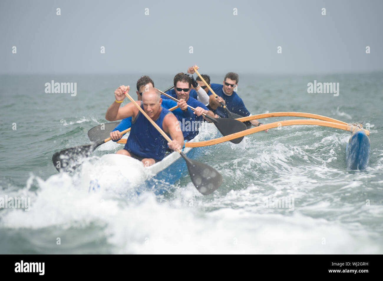 Crew of a racing outrigger canoe on water Stock Photo - Alamy