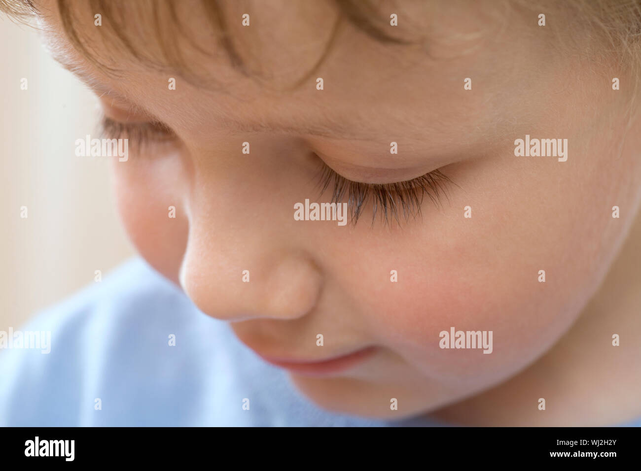 Closeup of cute little boy looking down Stock Photo - Alamy
