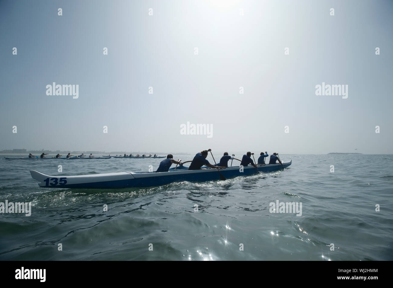 Group of multiethnic people paddling outrigger canoes in race Stock ...