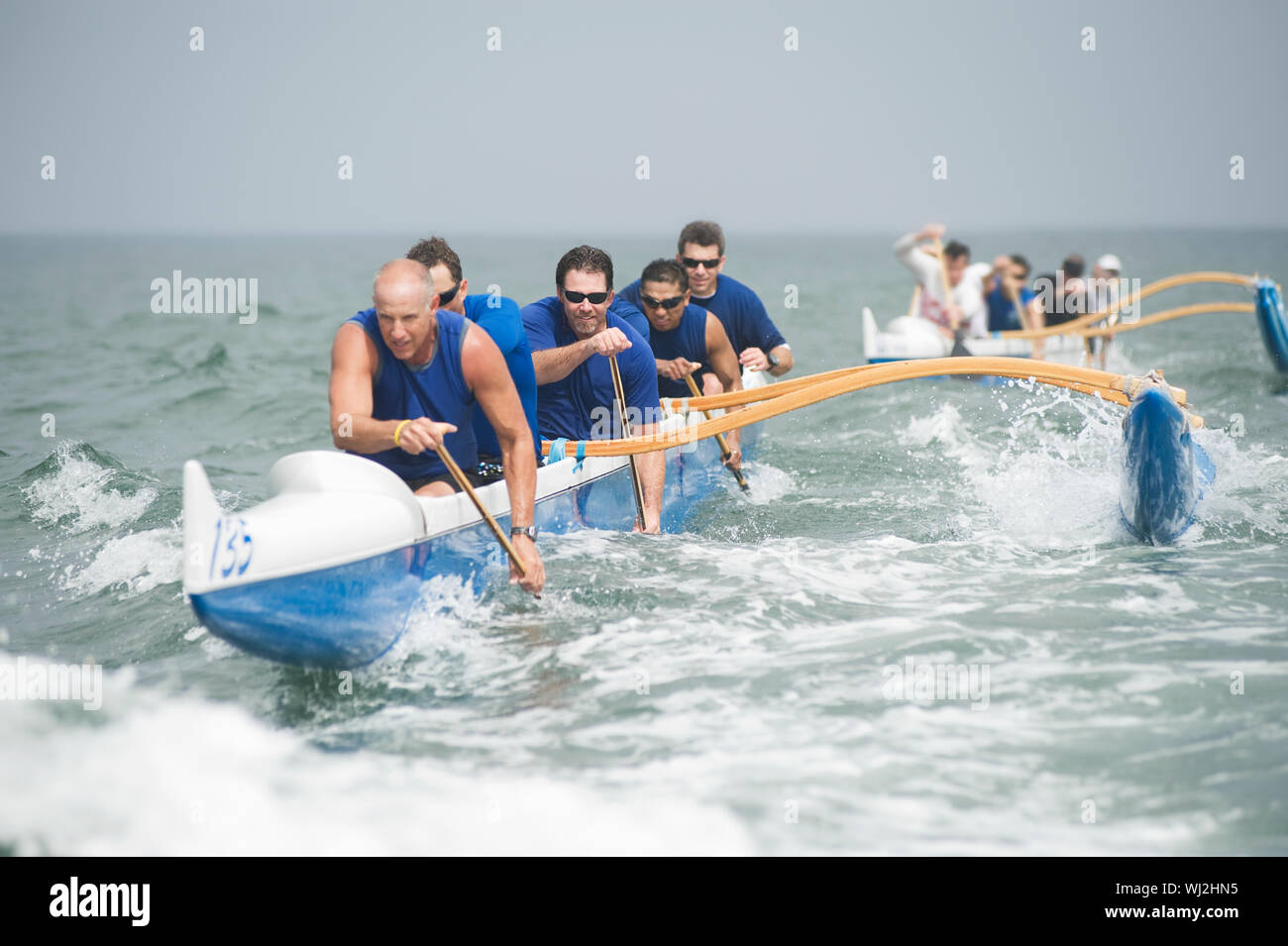 Crew of a racing outrigger canoe on water Stock Photo - Alamy