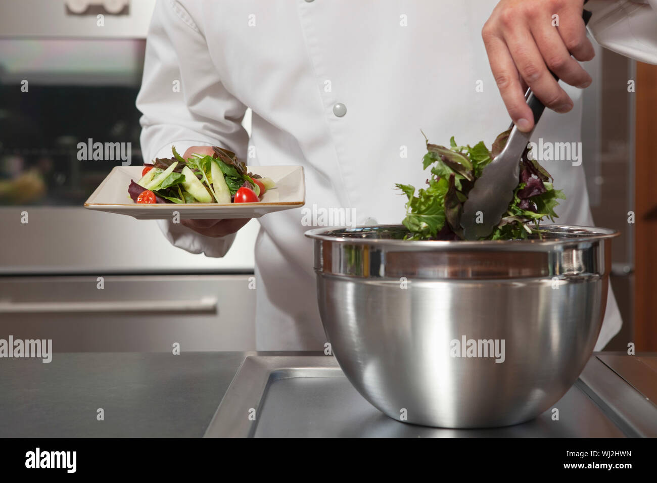 Male chef preparing leaf vegetables in commercial kitchen Stock Photo ...