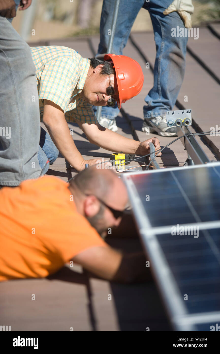 Male engineers working on solar panel at rooftop Stock Photo - Alamy