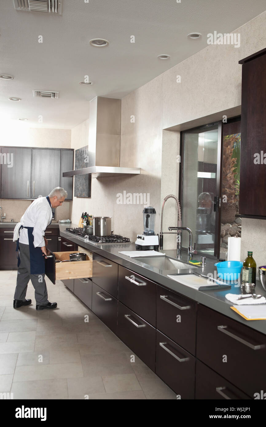 Side view of male chef working in commercial kitchen at restaurant ...