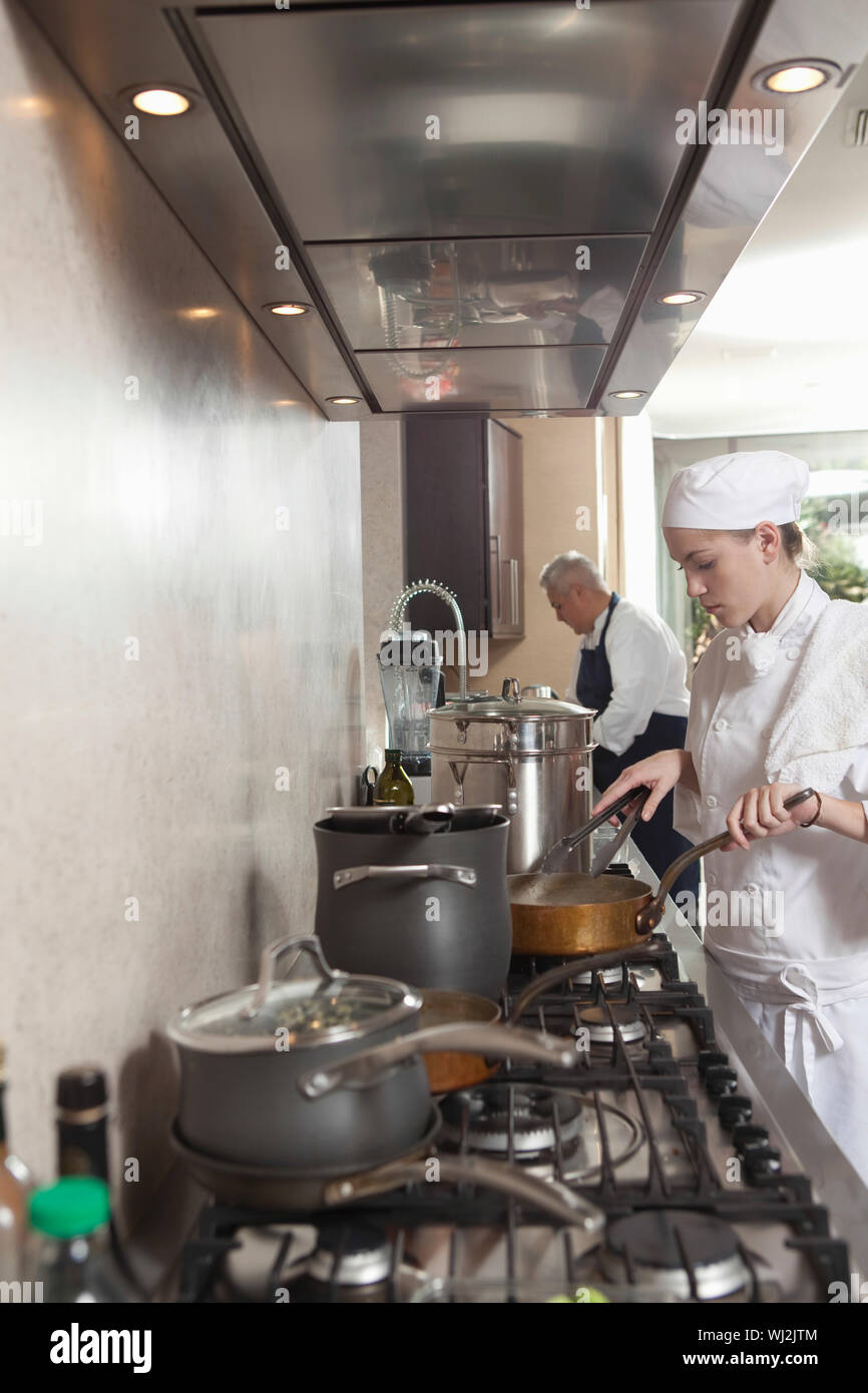 Side view of male and female chefs working in commercial kitchen Stock ...