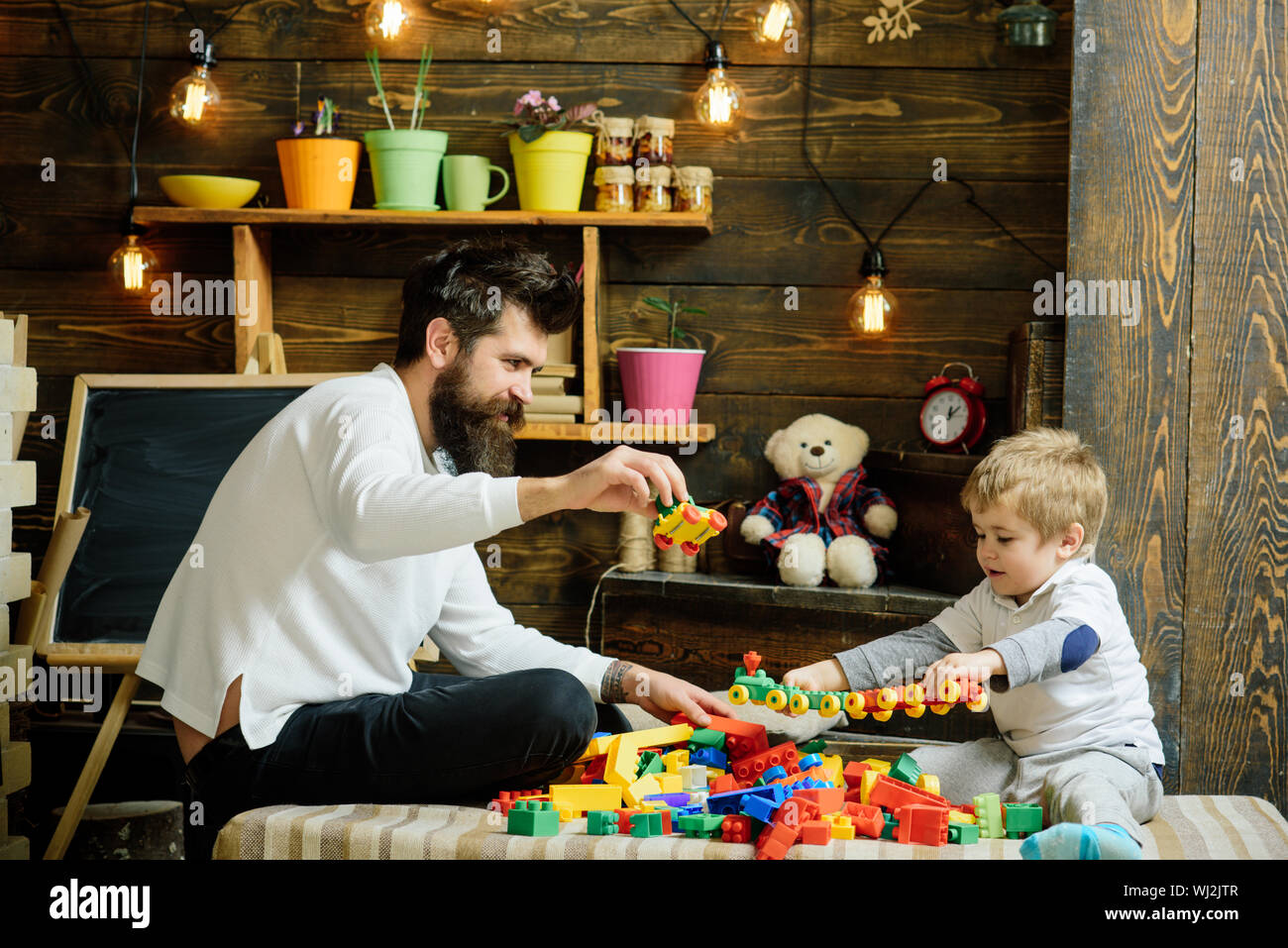 Dad and child play with toy cars, bricks. Father and happy son play ...