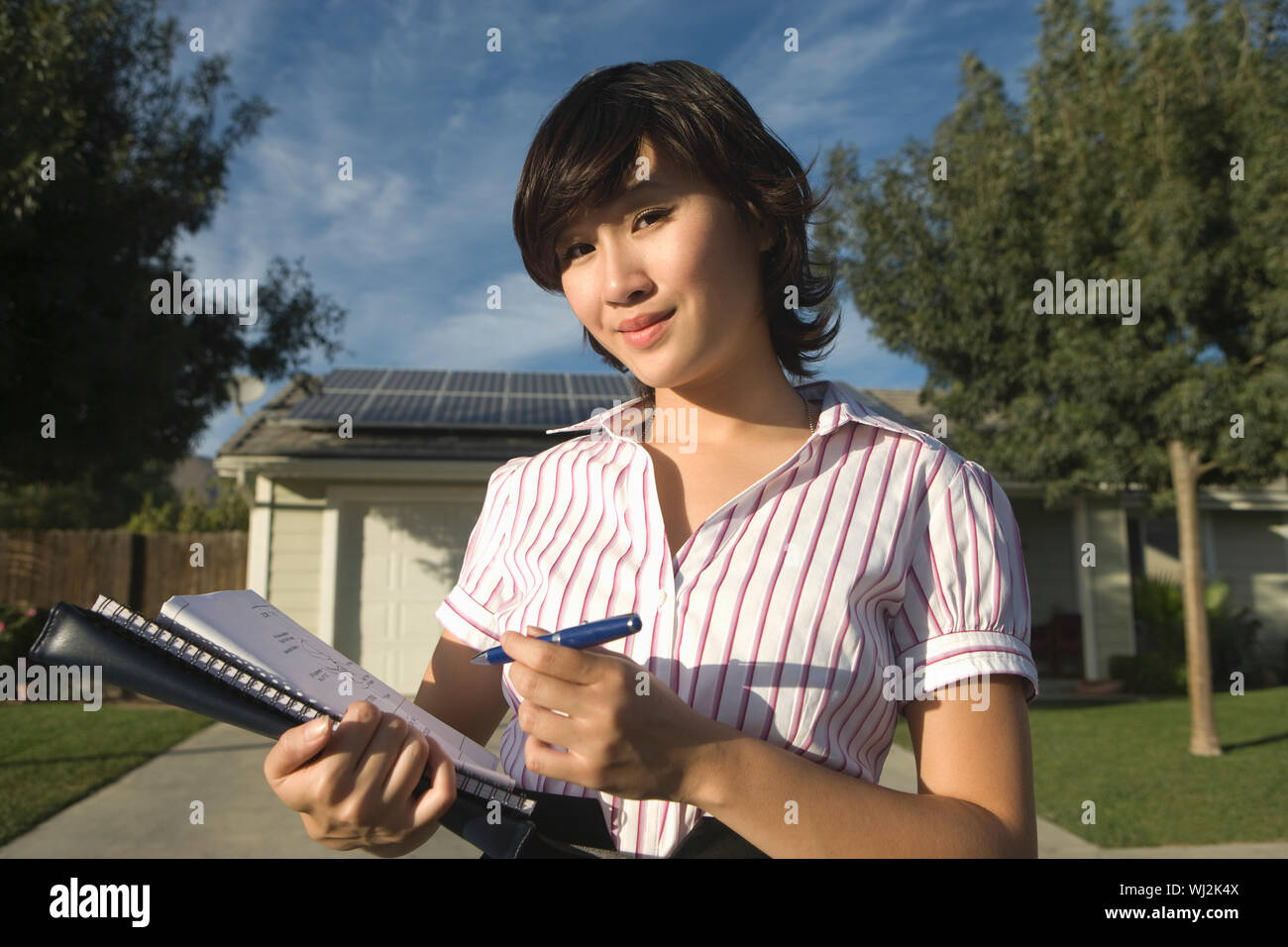 Portrait of young female solar panel worker working on blueprint ...