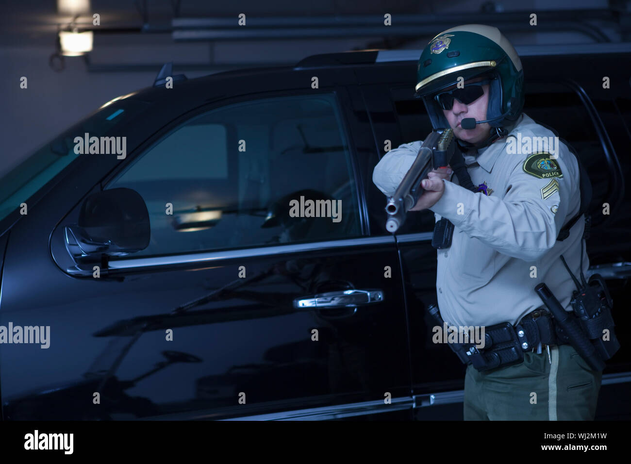 Confident traffic cop aiming rifle while standing against car Stock ...