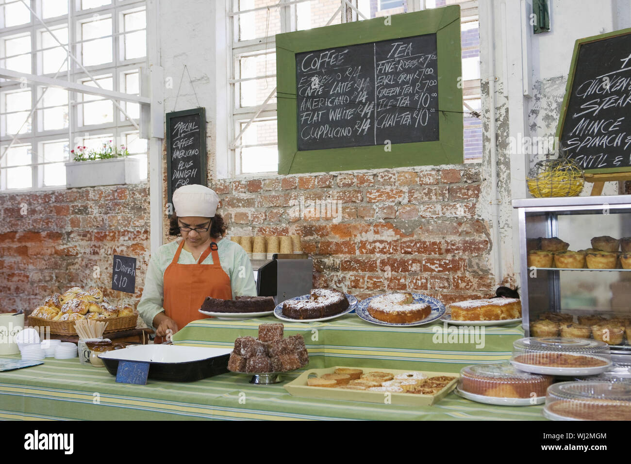 Middle aged female owner working at cake shop Stock Photo - Alamy