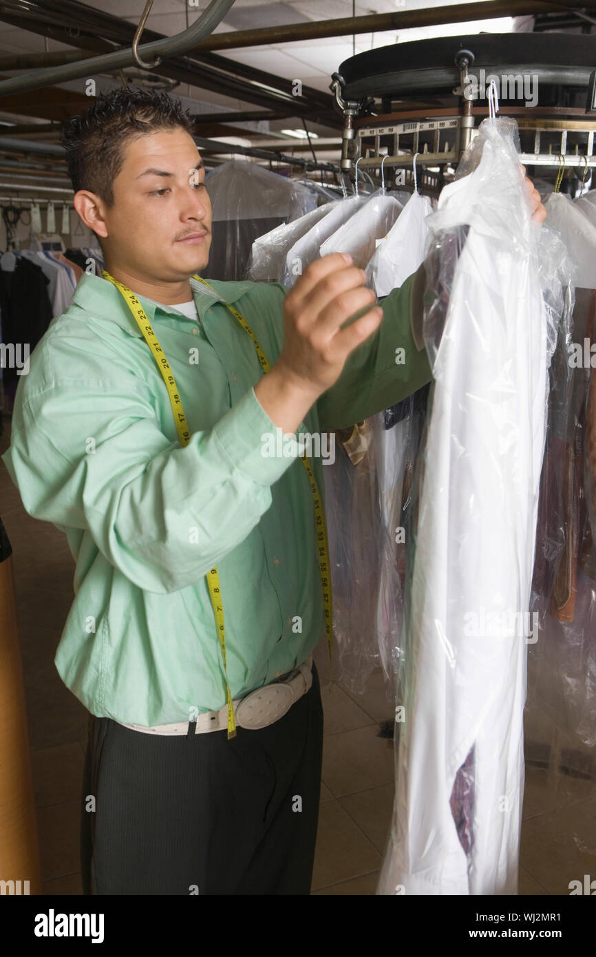 Young male owner working in laundry Stock Photo - Alamy