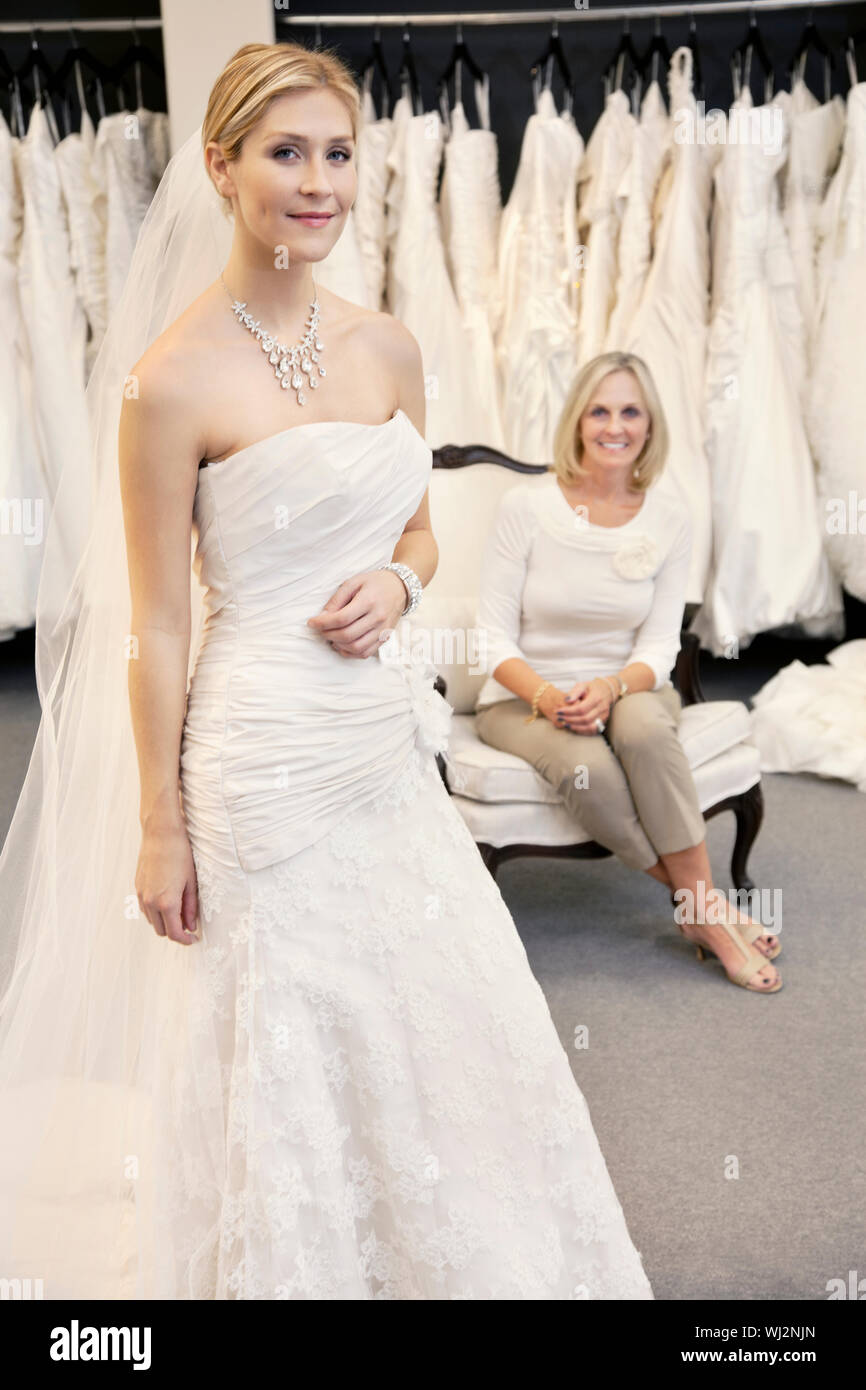 Portrait of a beautiful young woman in wedding dress with mother ...