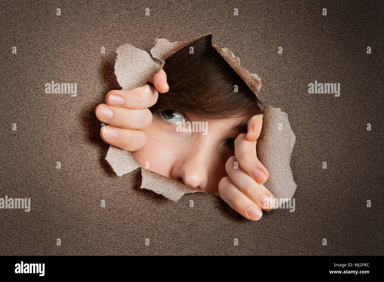 Young Middle eastern woman peeking from ripped white paper hole Stock ...