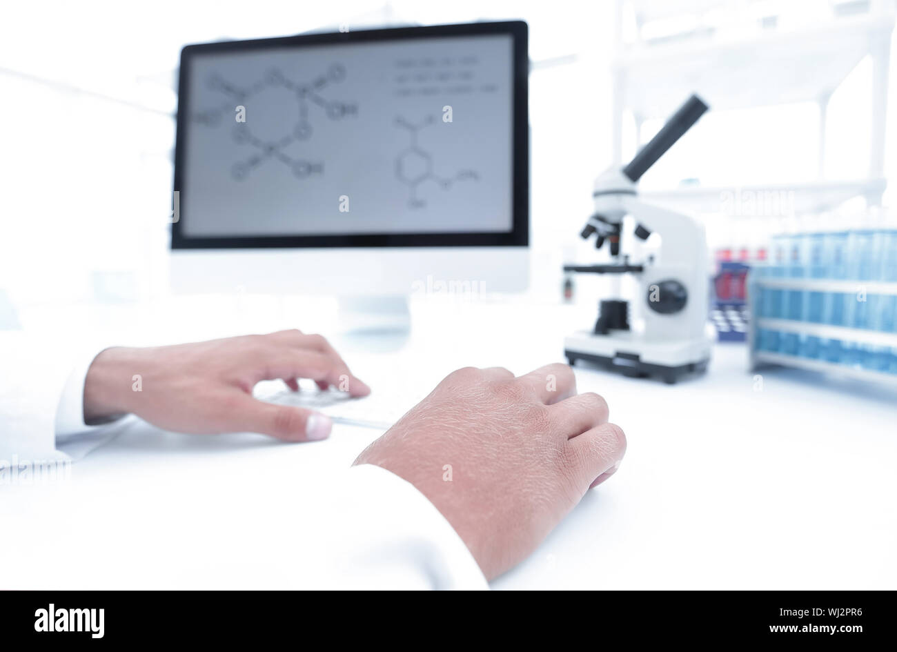 A scientist uses a computer and a microscope Stock Photo - Alamy