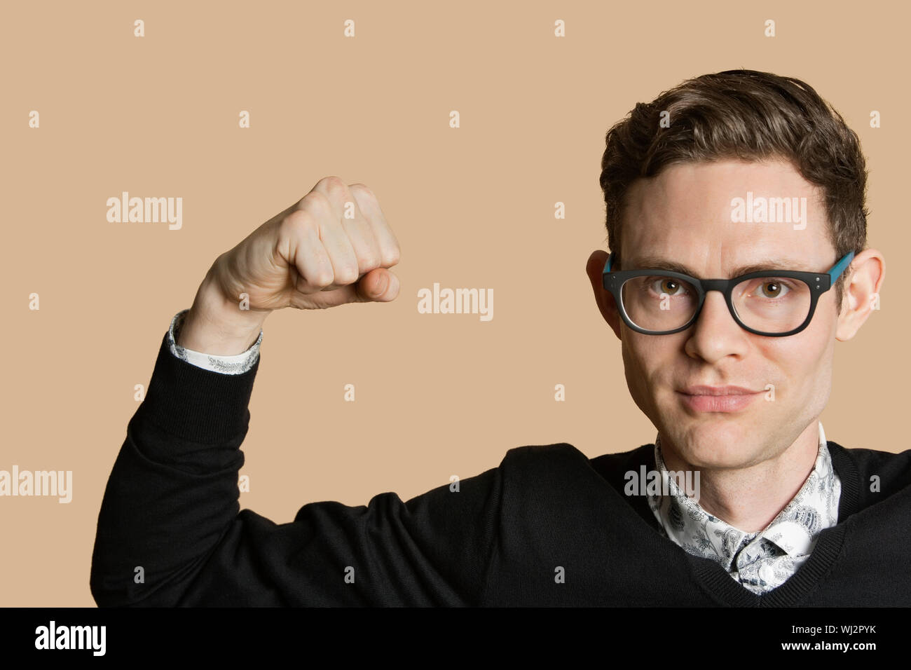 Portrait of a mid adult man flexing muscles over colored background ...