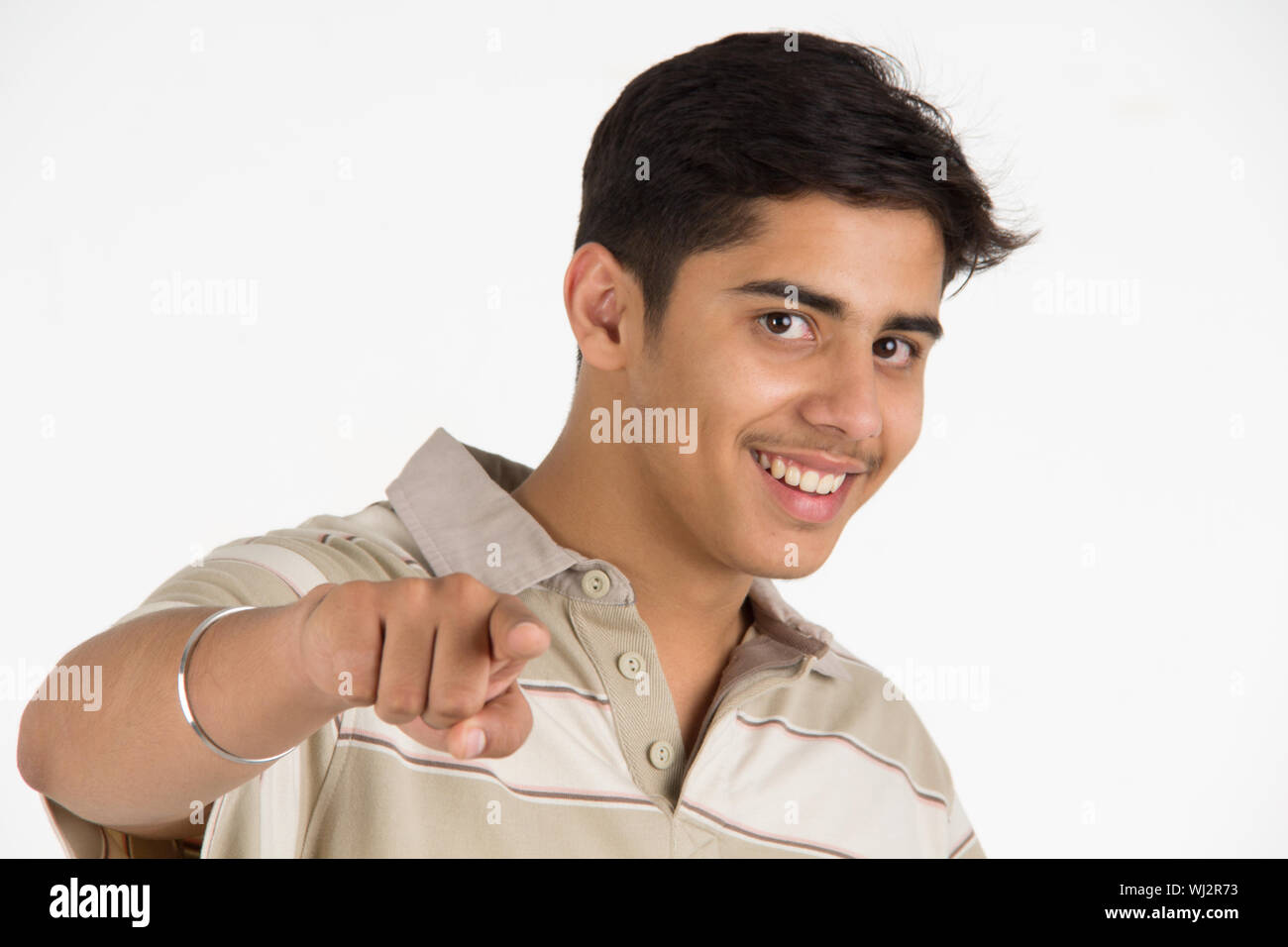 Young man pointing towards camera and smiling Stock Photo - Alamy