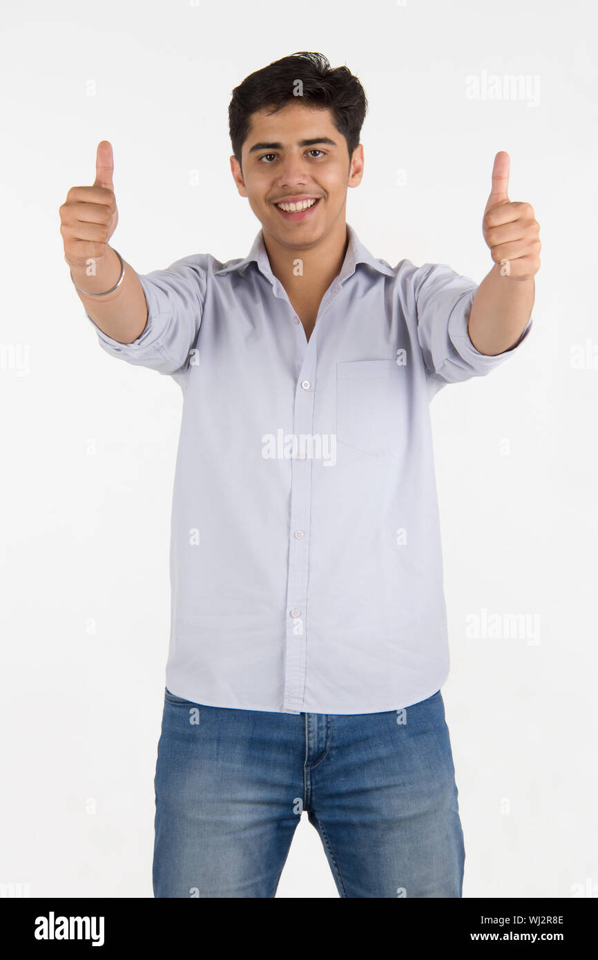 Young man standing and showing thumbs up sign from both hands Stock ...