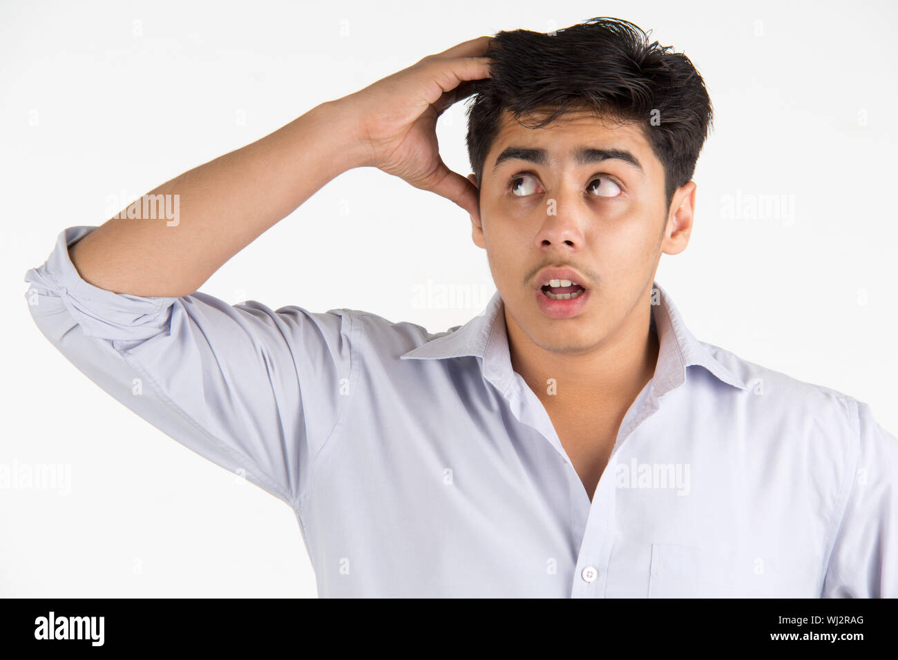 Nervous young man scratching head Stock Photo - Alamy