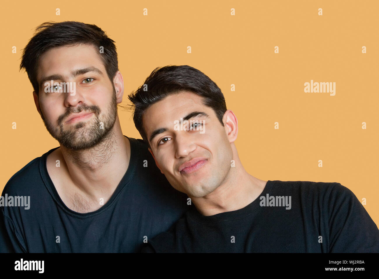 Portrait of young male friends over colored background Stock Photo - Alamy