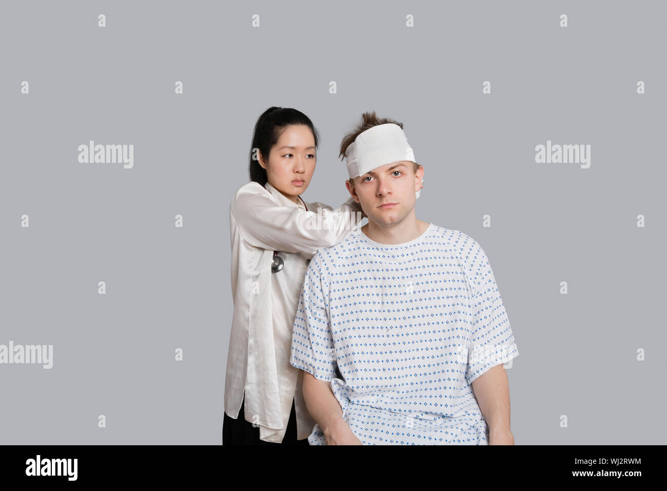 Female doctor dressing patient's head with bandage Stock Photo - Alamy