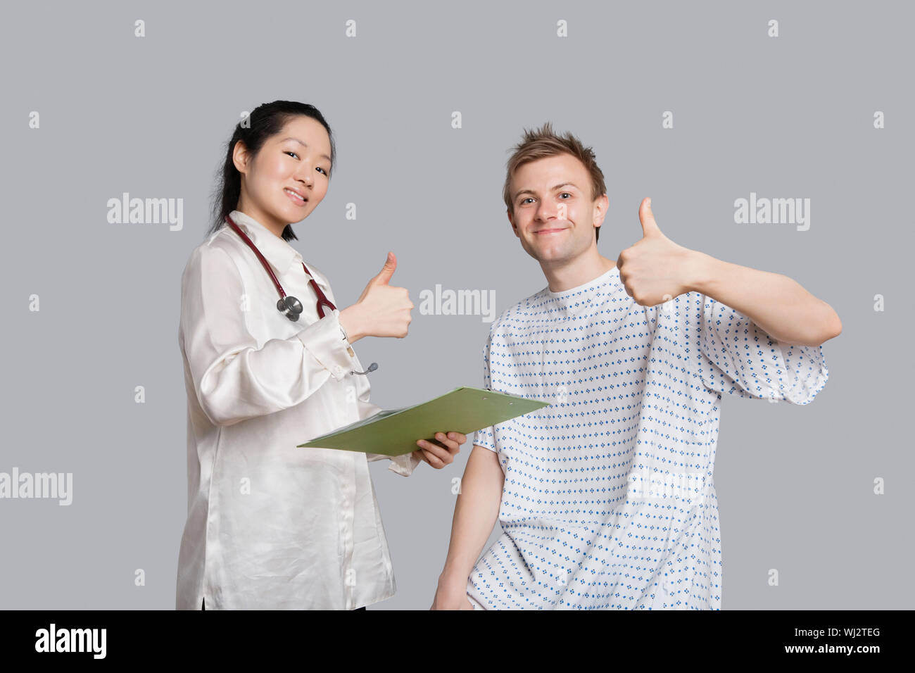 Portrait of happy doctor and patient gesturing thumbs up Stock Photo ...