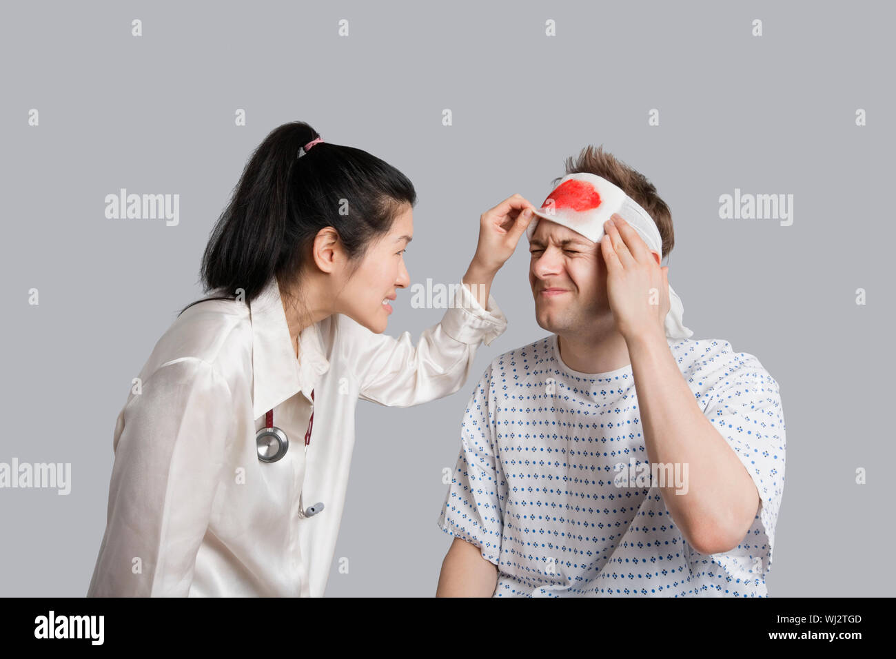 Patient suffering from pain while doctor examining him Stock Photo - Alamy