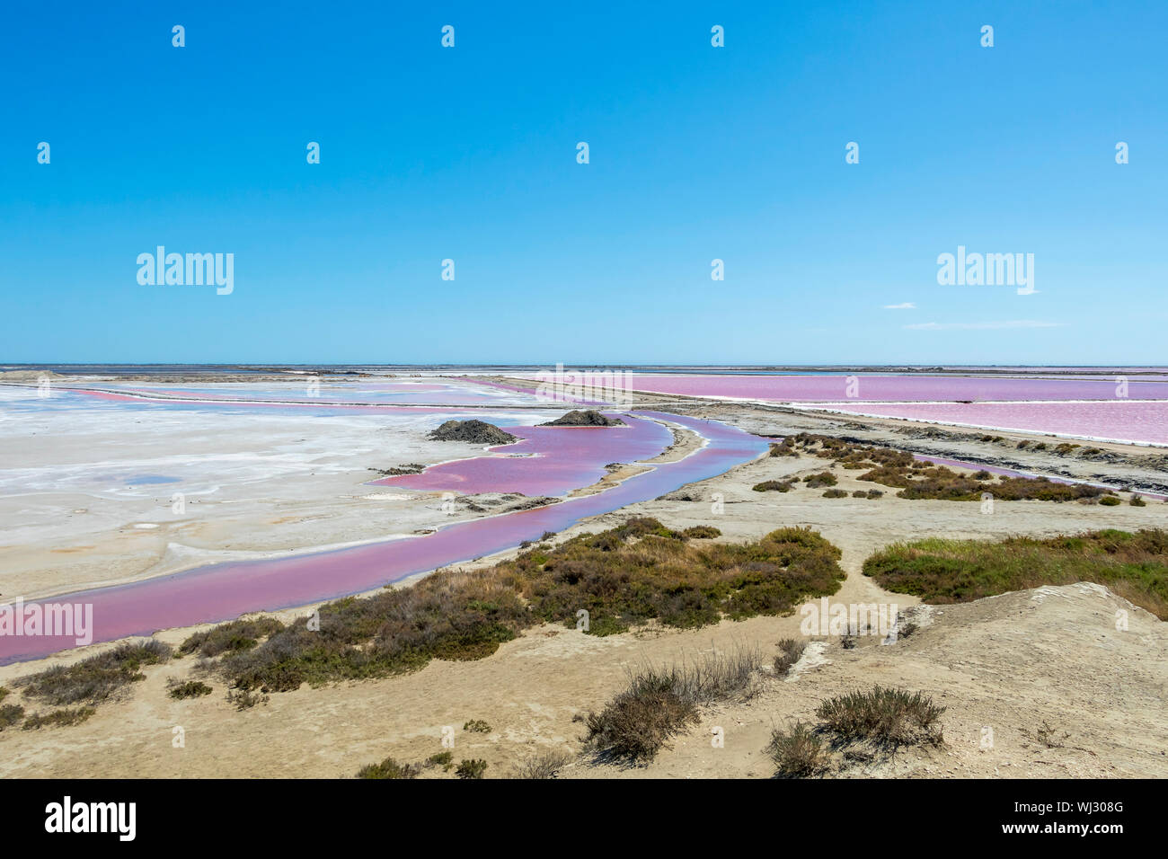 The Salin-de-Giraud salt farm with pink purple salty sea water in man ...