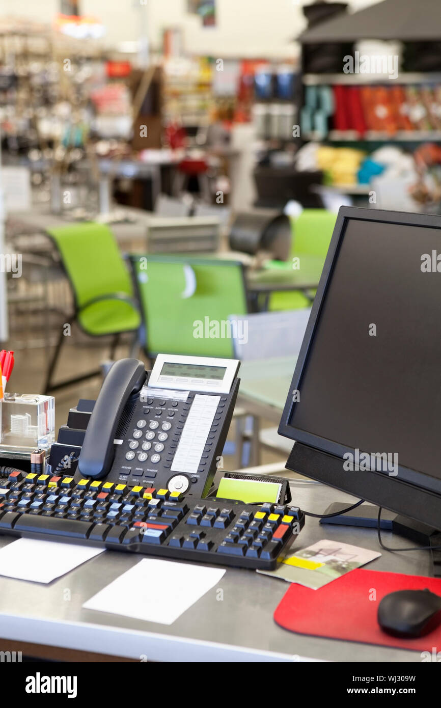 Computer with landline phone in store counter Stock Photo - Alamy