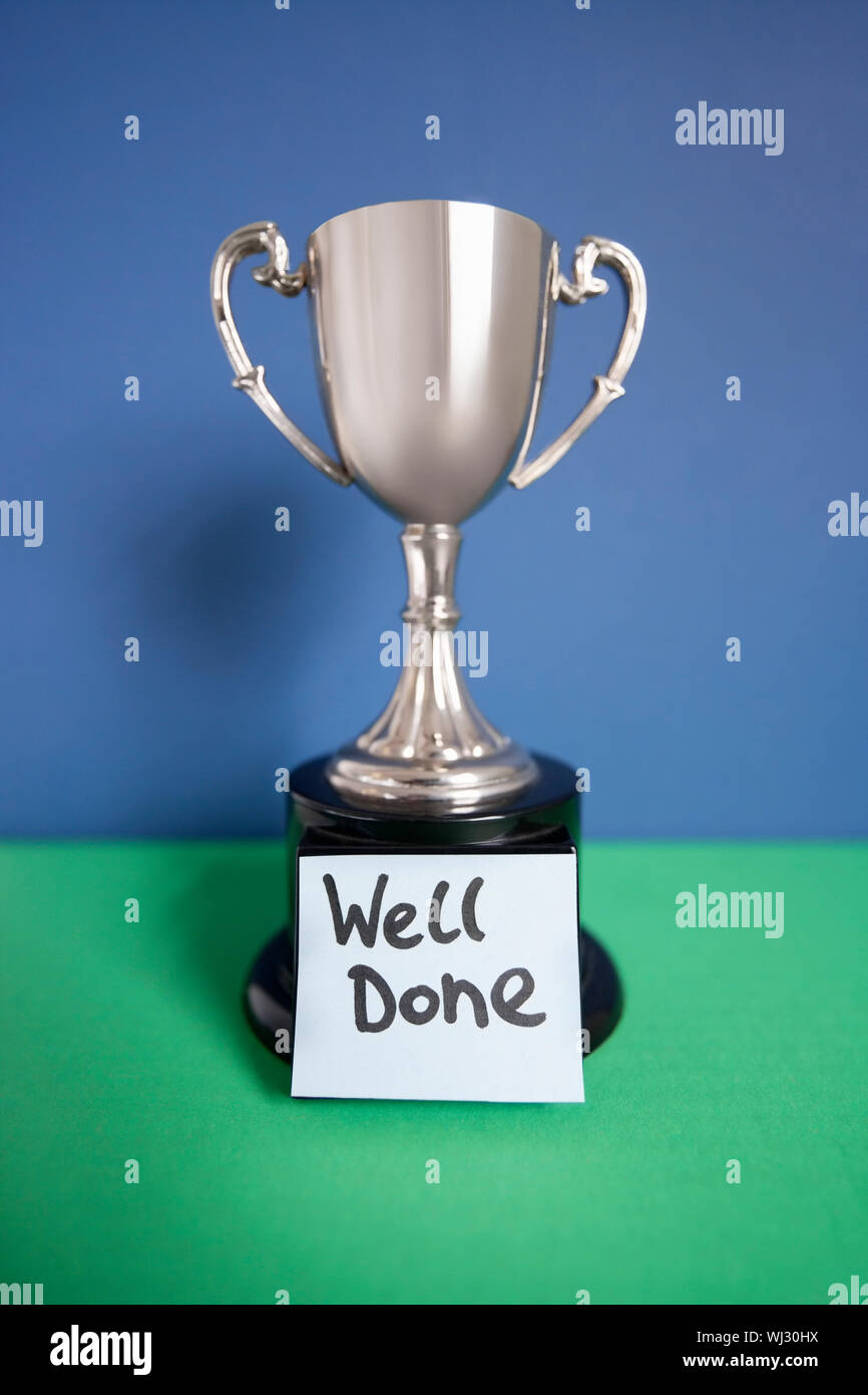 Winning trophy award with sticky note over colored background Stock ...