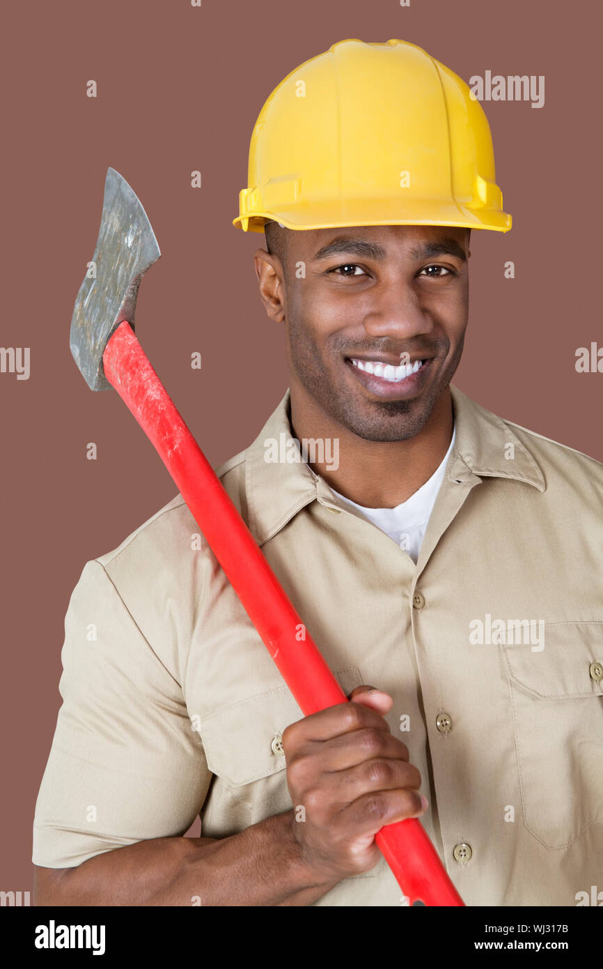 Portrait of young African man holding axe on shoulder over colored ...
