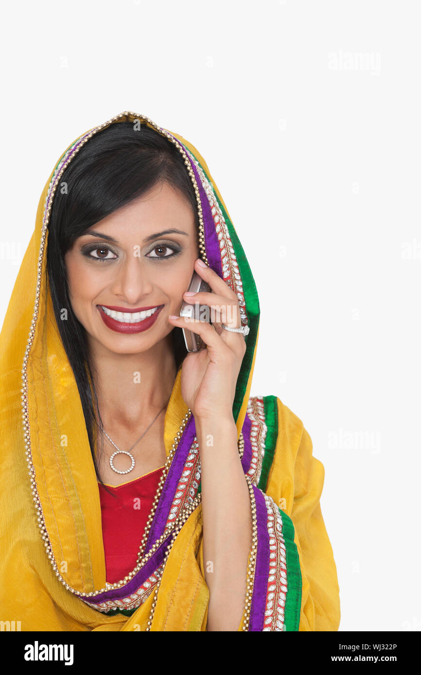 Portrait of Indian woman in traditional wear attending phone call over ...